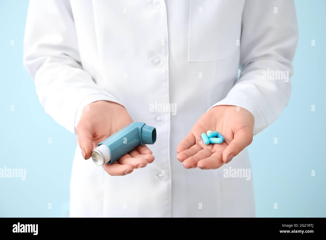 Female allergist with inhaler and pills on color background Stock Photo ...