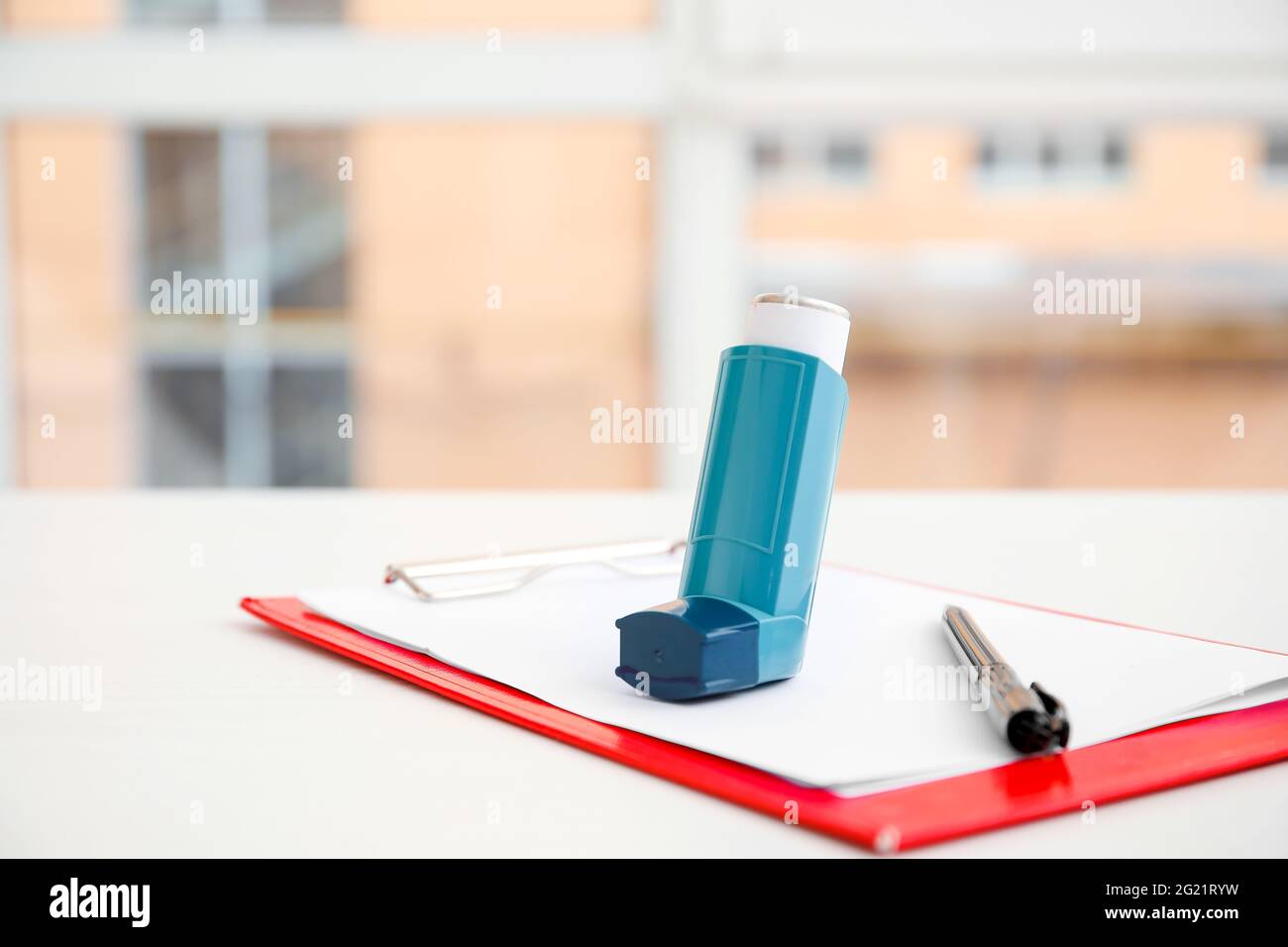 Modern inhaler and clipboard on table near window Stock Photo - Alamy