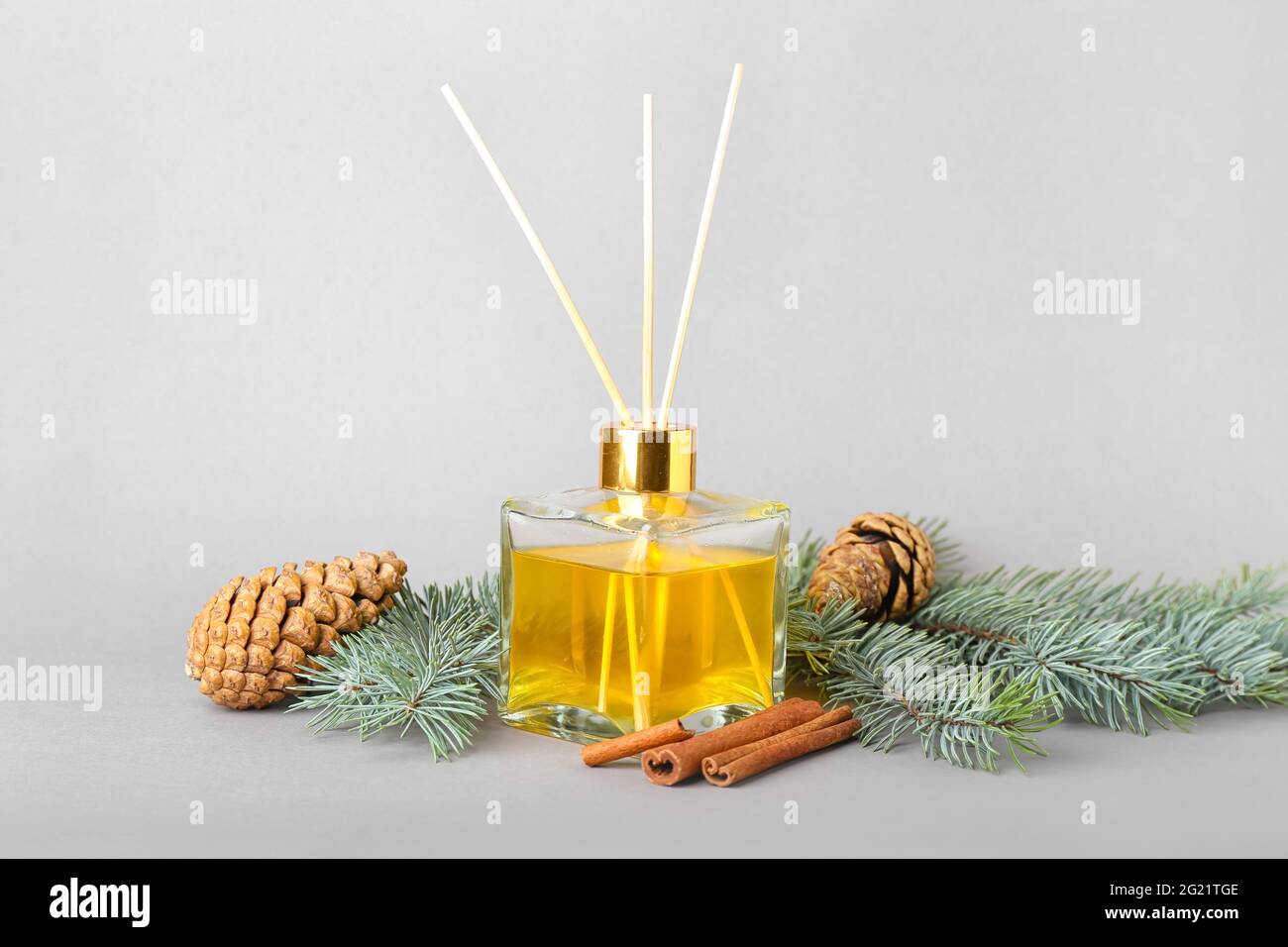 Coniferous reed diffuser with cinnamon on grey background Stock Photo ...