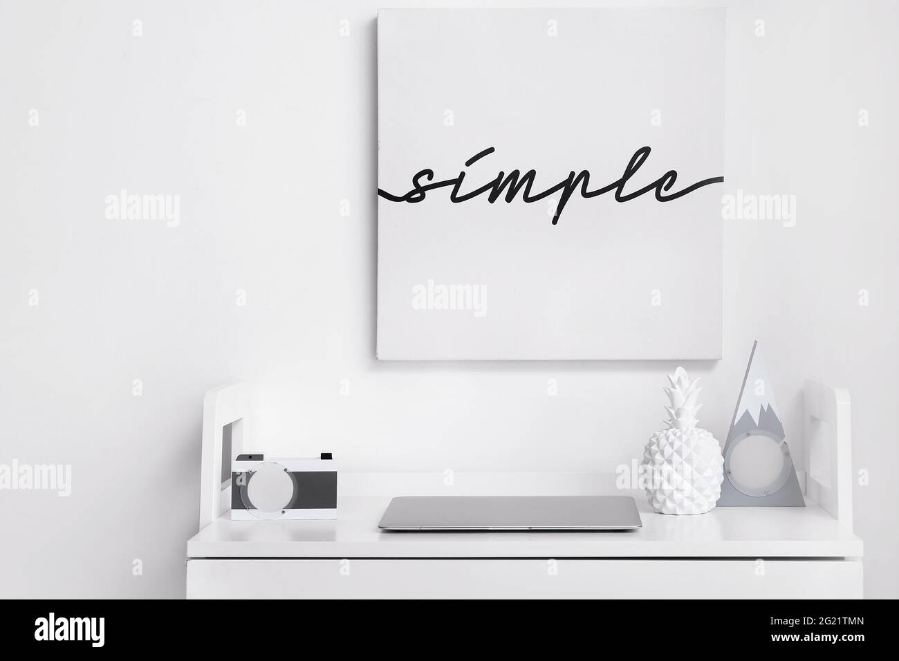 Modern workplace with laptop and decor near light wall Stock Photo - Alamy