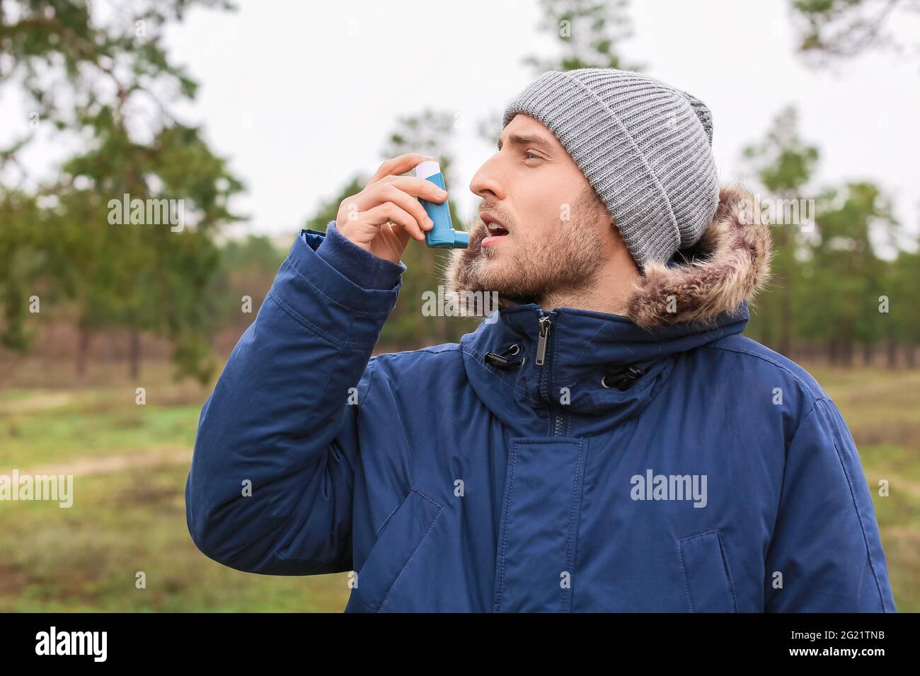 Young man with inhaler having asthma attack outdoors Stock Photo - Alamy