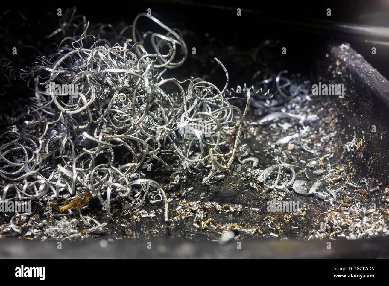 Silver spirals of swarf waste from aluminium metal being turned or cut ...