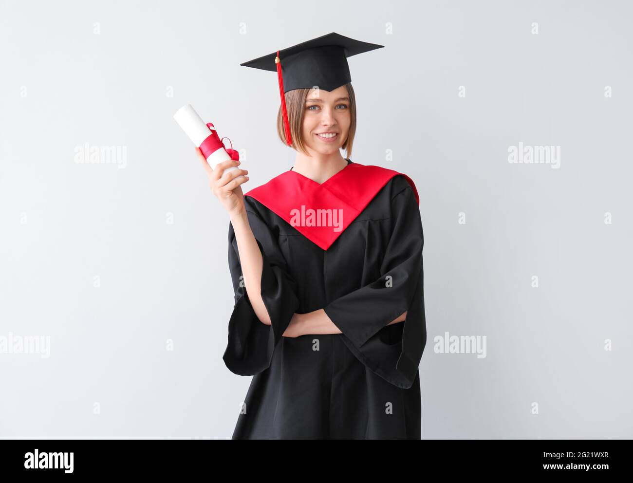 Female graduating student with diploma on light background Stock Photo ...