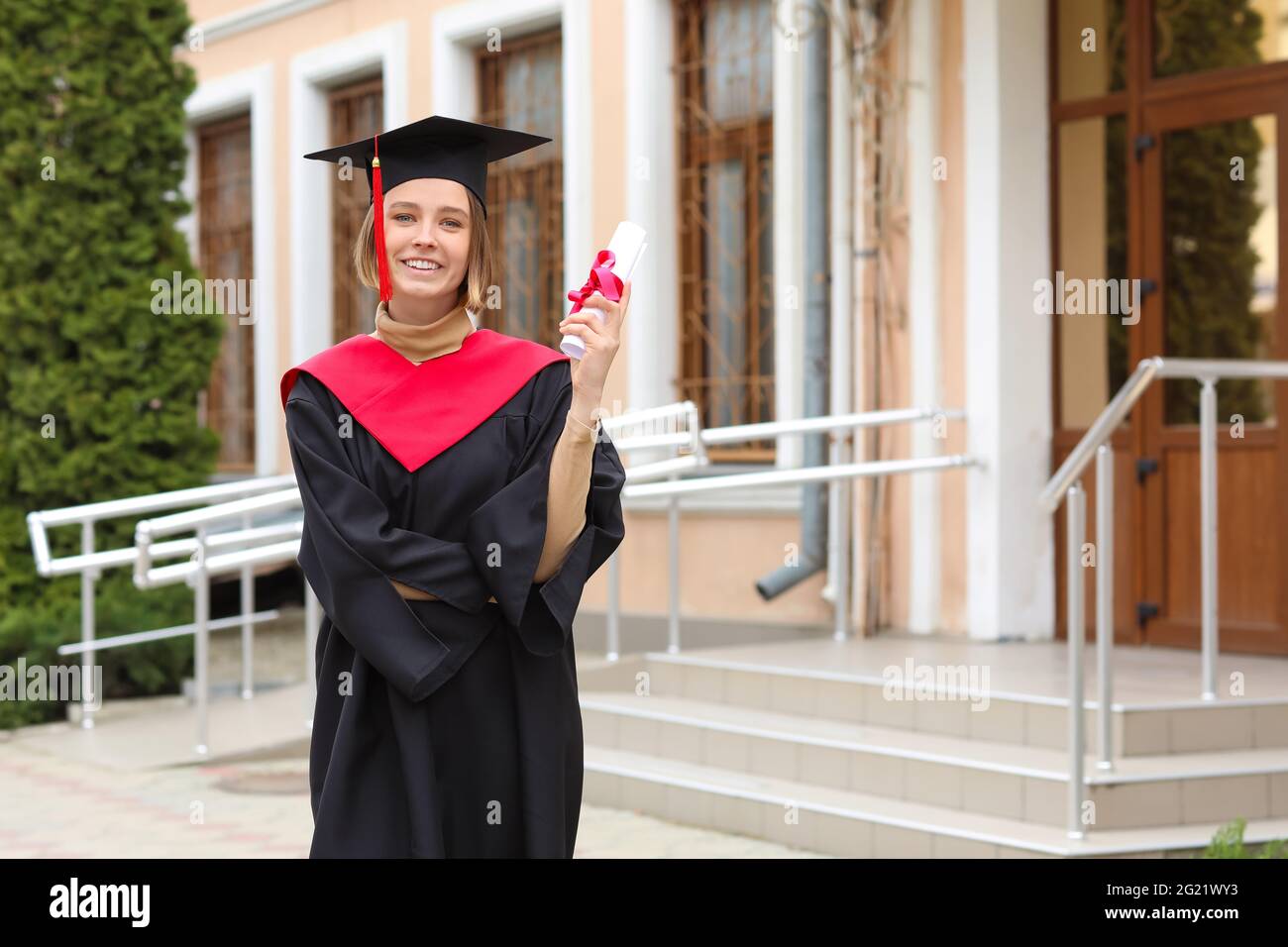 Female student in bachelor robe and with diploma on her graduation day ...