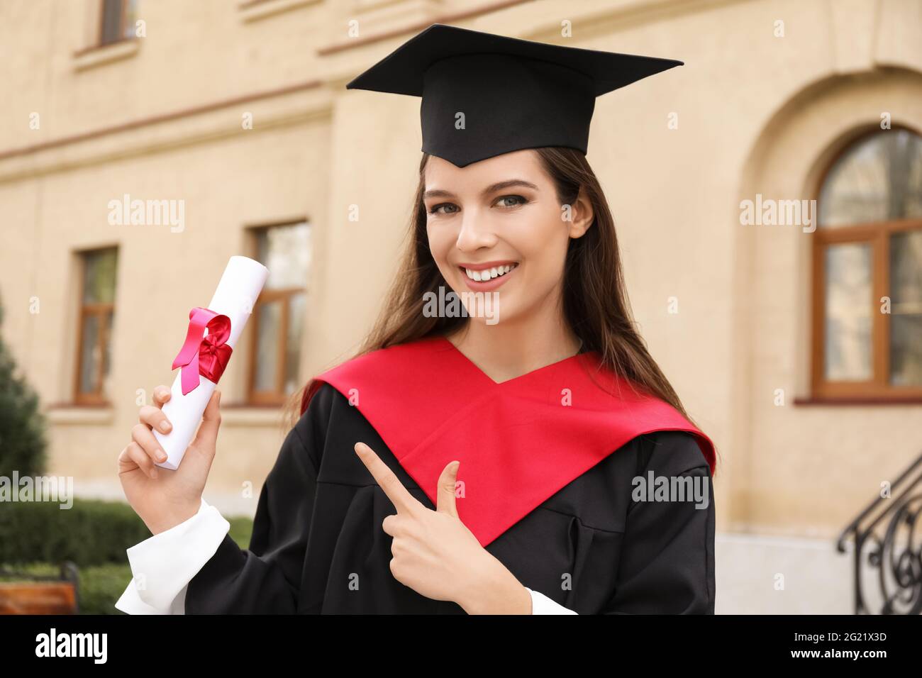 Female student in bachelor robe and with diploma on her graduation day ...