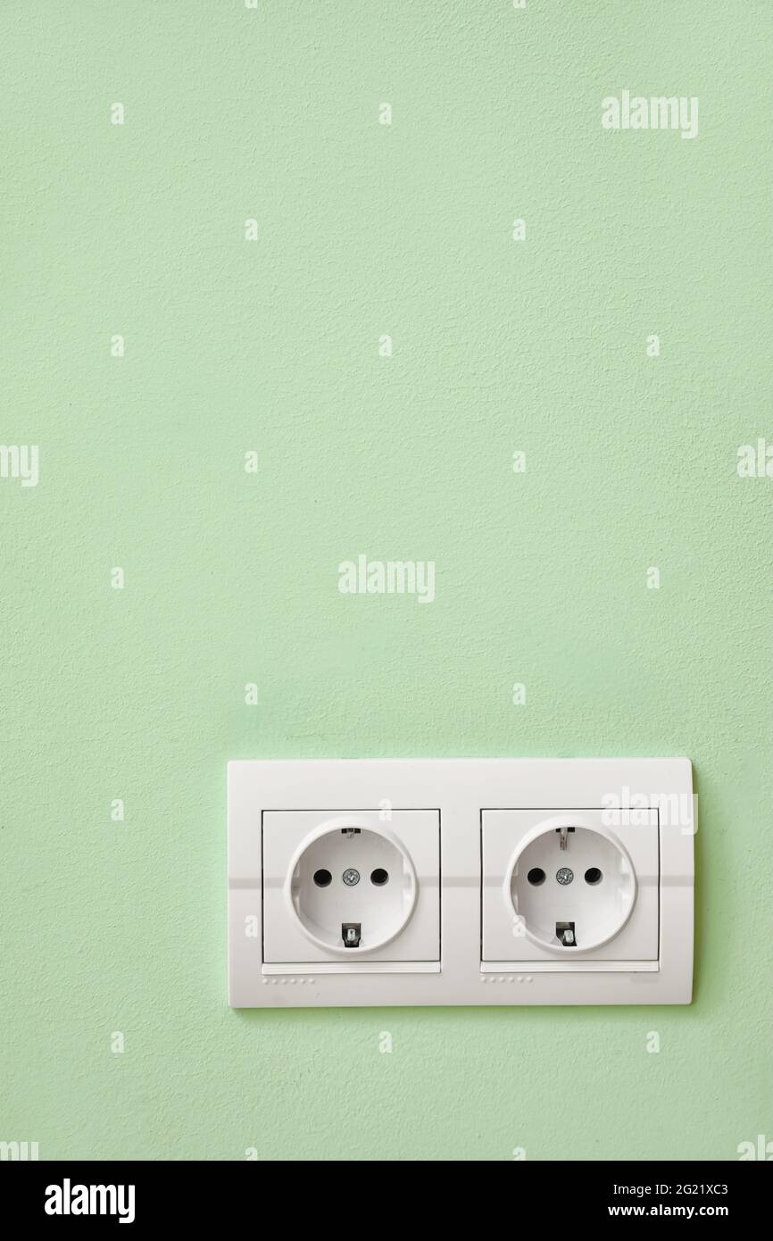 Electric socket on color wall Stock Photo - Alamy