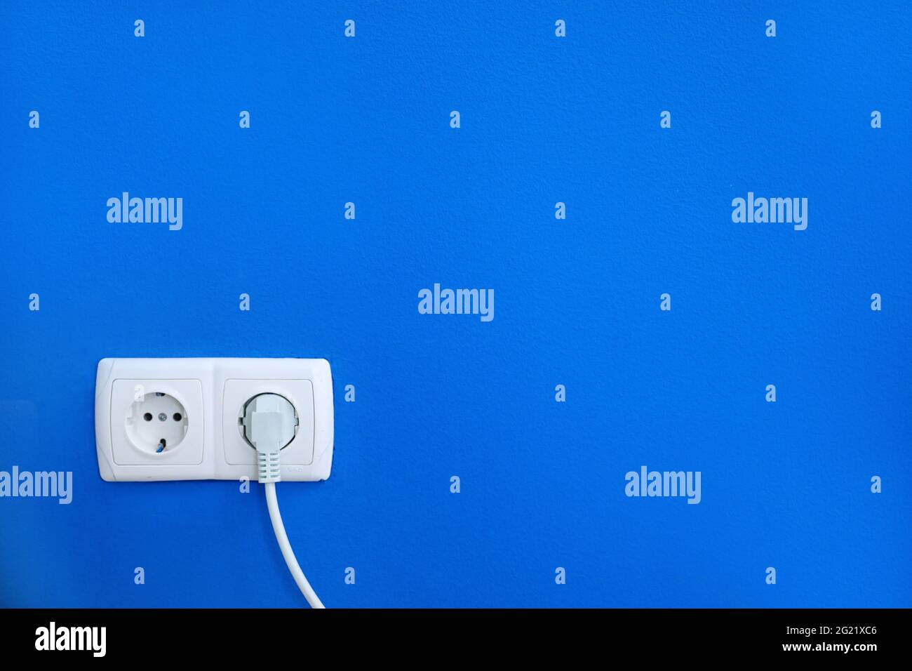Electric socket with plug on color wall Stock Photo - Alamy