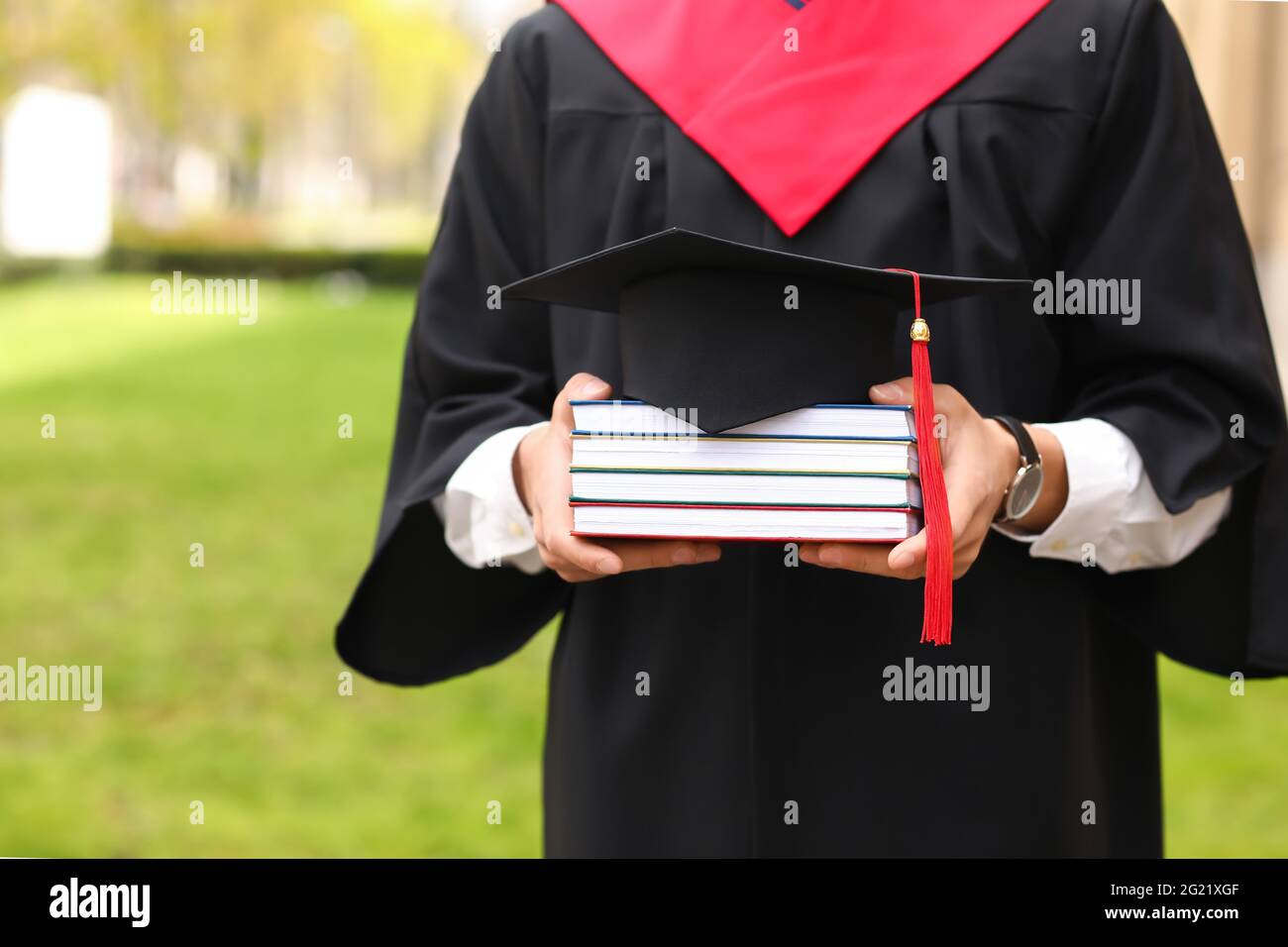 Male graduating student with books outdoors Stock Photo - Alamy