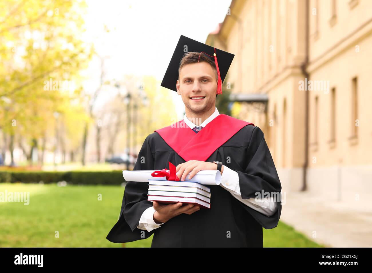 Male graduating student with books outdoors Stock Photo - Alamy