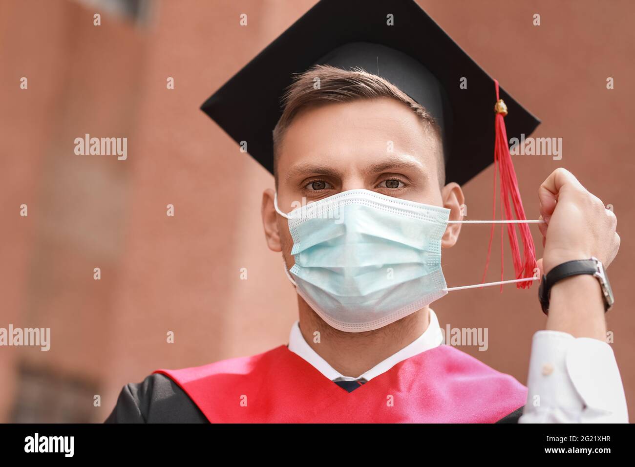 Male graduating student wearing medical mask outdoors Stock Photo - Alamy