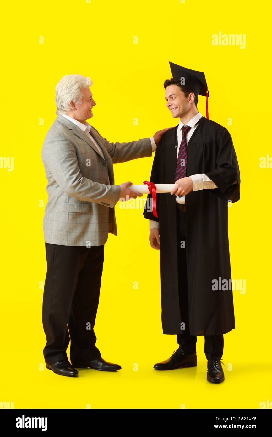 Happy male graduation student with his father on color background Stock ...