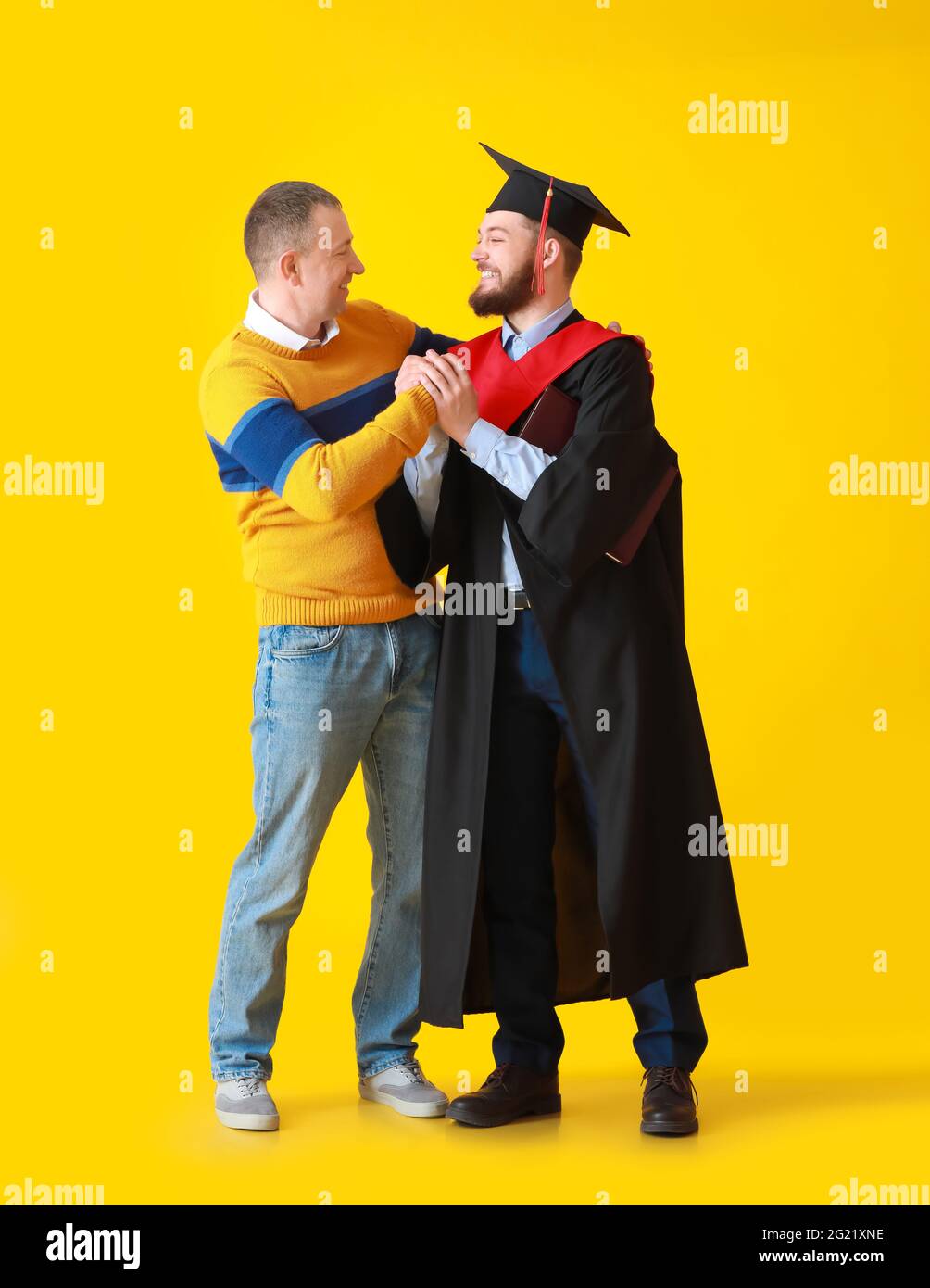 Happy male graduation student with his father on color background Stock ...