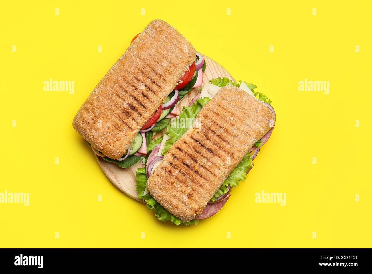 Board with tasty ciabatta sandwiches on color background Stock Photo ...