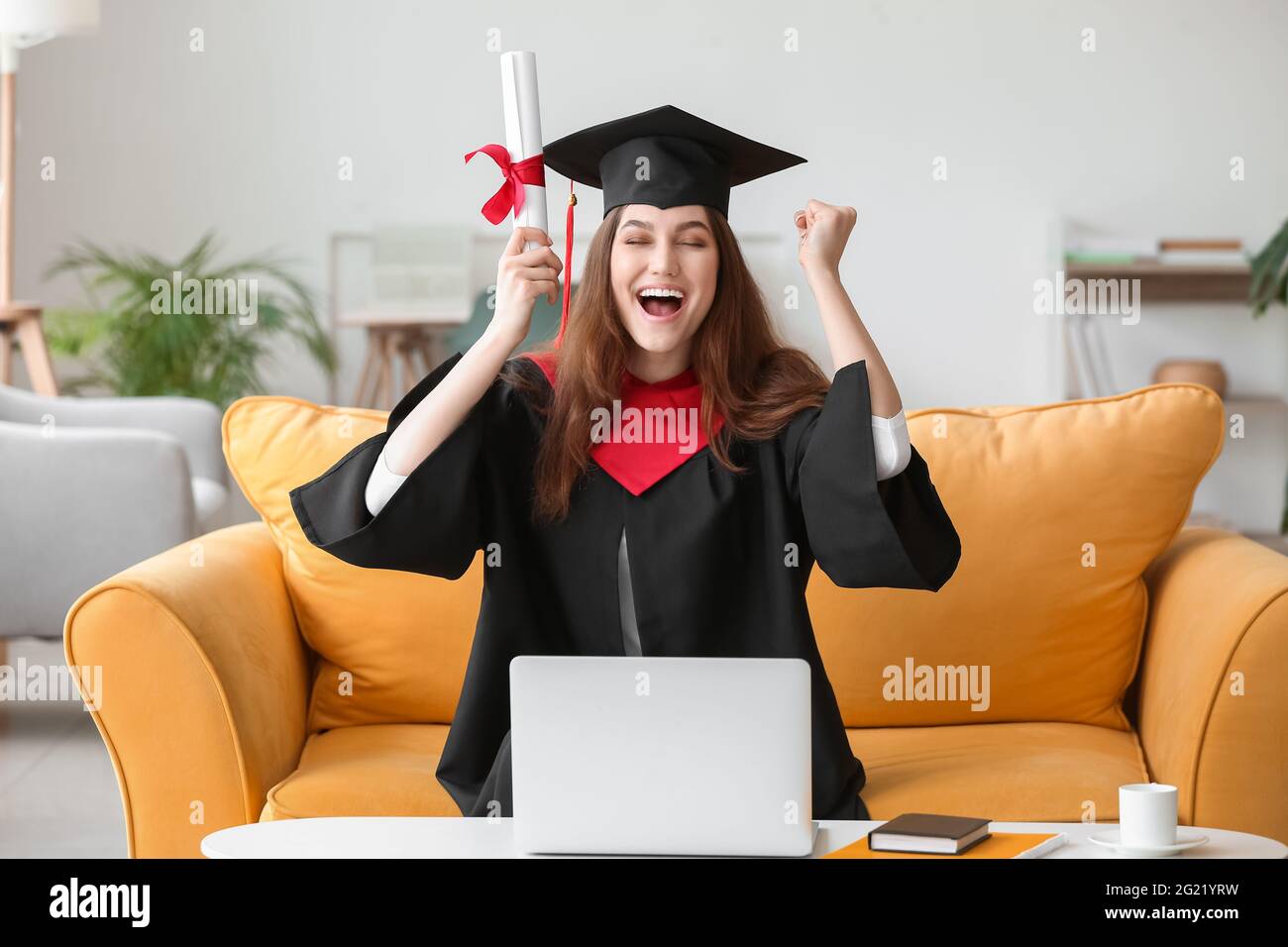 Happy female student on her graduation day at home. Concept of studying ...