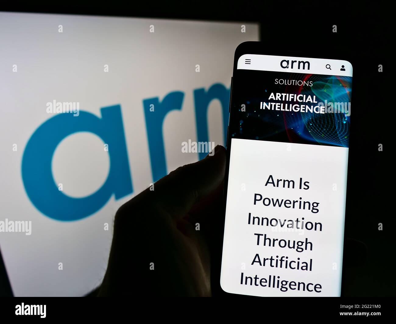 Person holding smartphone with web page of British semiconductor ...