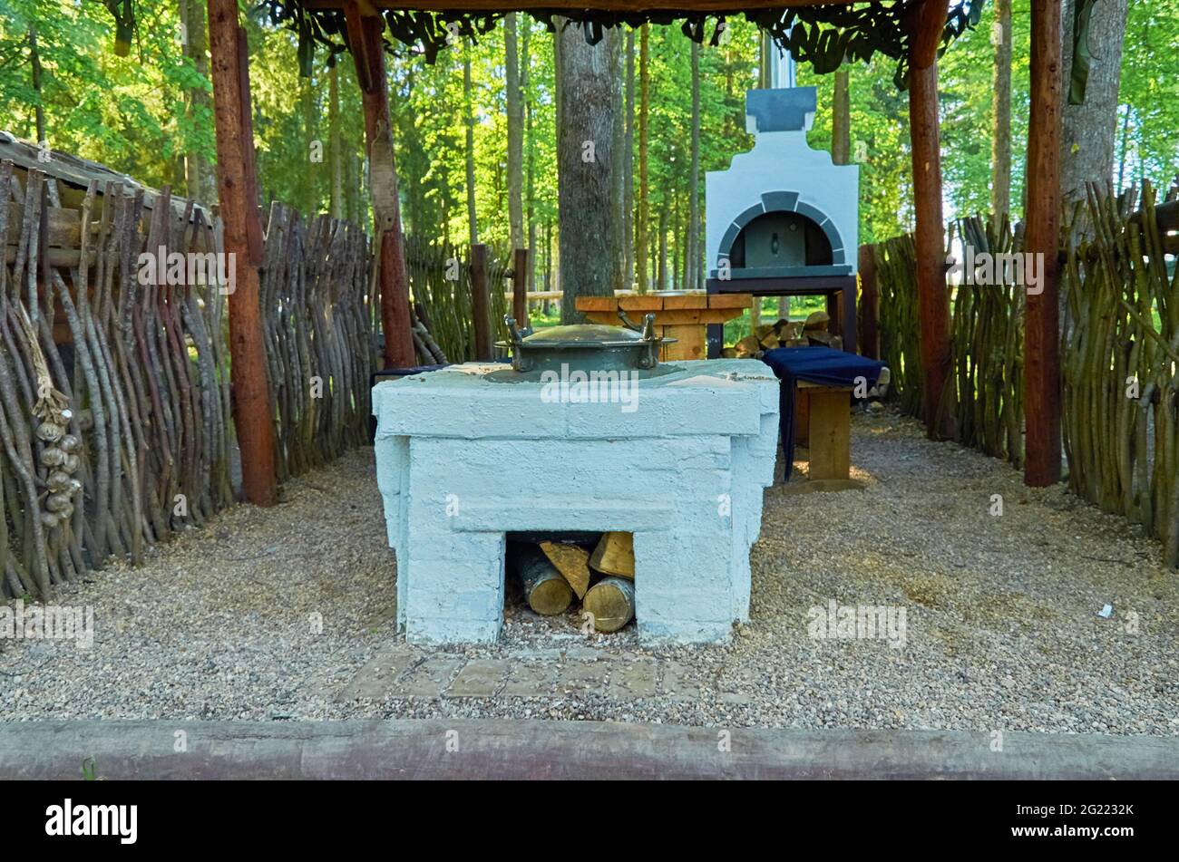 Summer kitchen with two stoves, wooden table and bench Stock Photo - Alamy