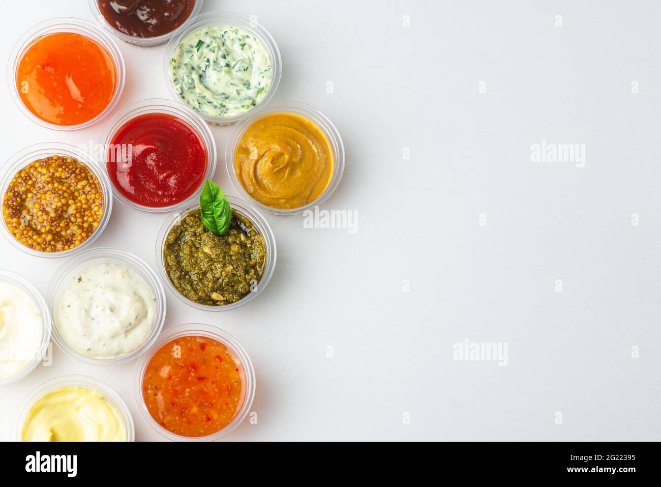Top view on big assortment of different sauces on white background ...