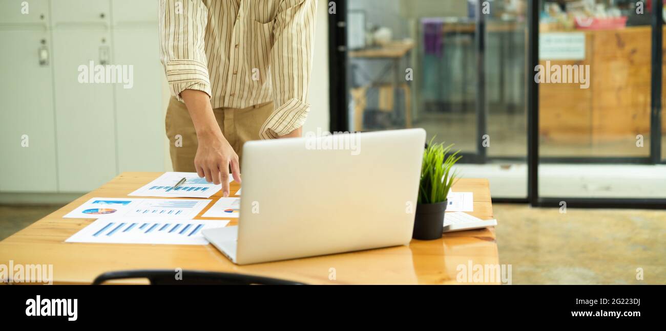 Cropped shot of businessperson working with laptop and paperwork in ...