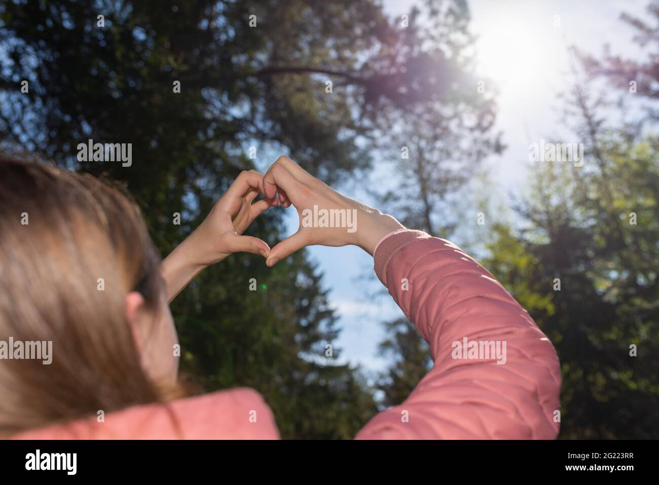 Hands in heart shape. Teenage girl hands heart shape on against blurry ...