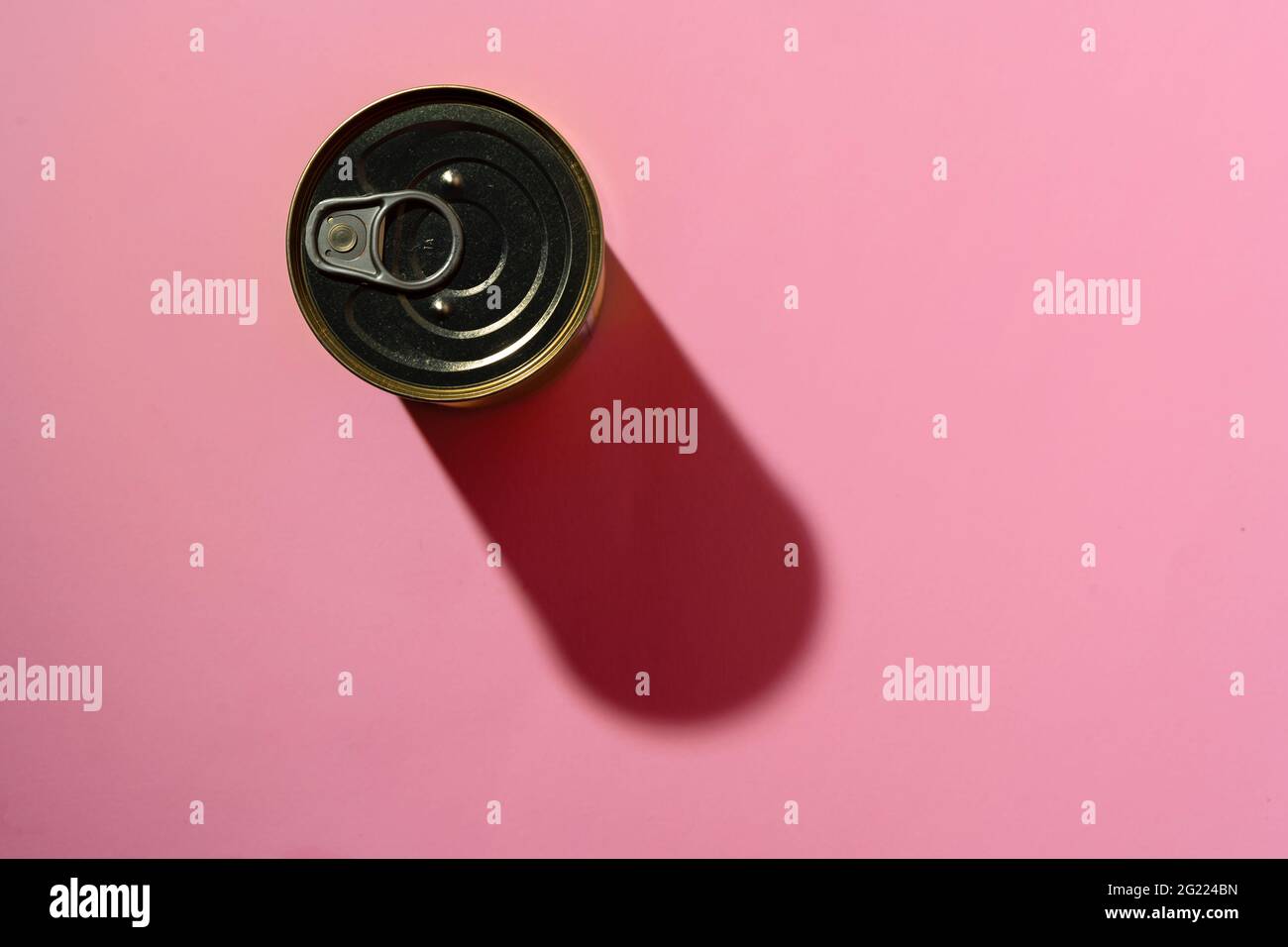 Canned food tin on pink studio background Stock Photo - Alamy