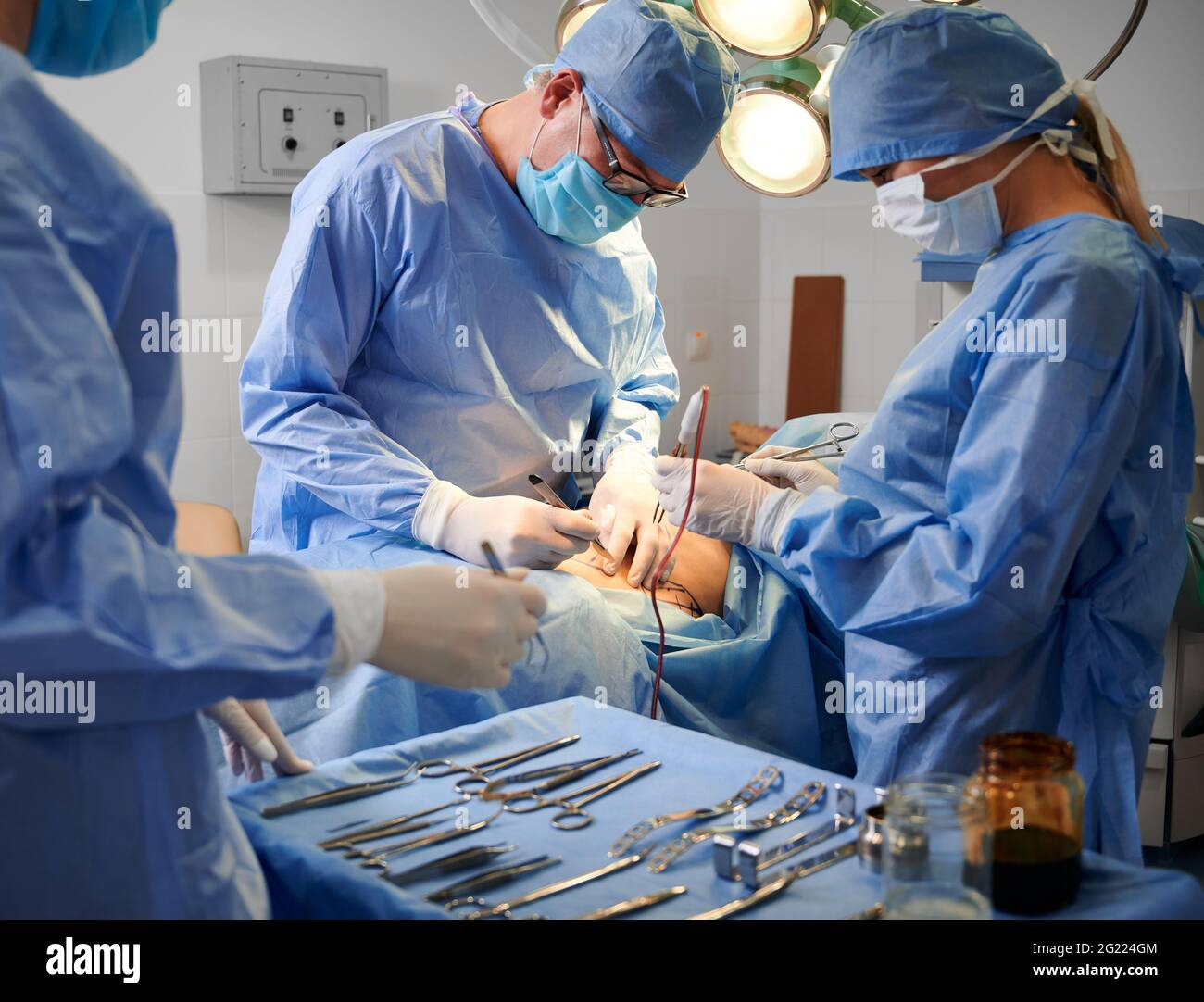 Surgical team in sterile gloves and protective face masks doing plastic ...