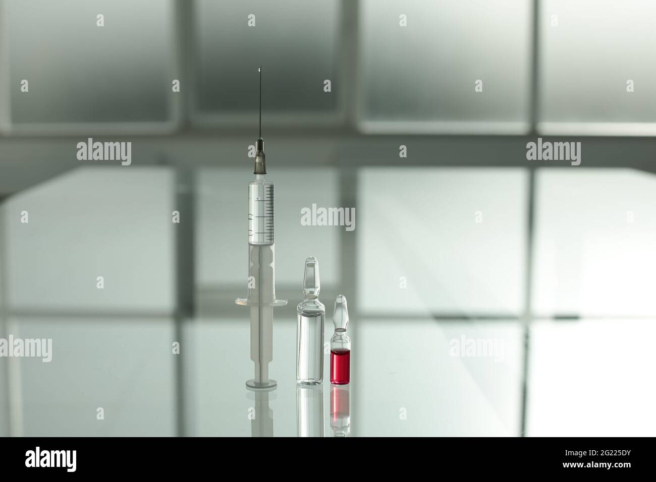 Medicine vials and syringe on glass table in hospital room Stock Photo ...
