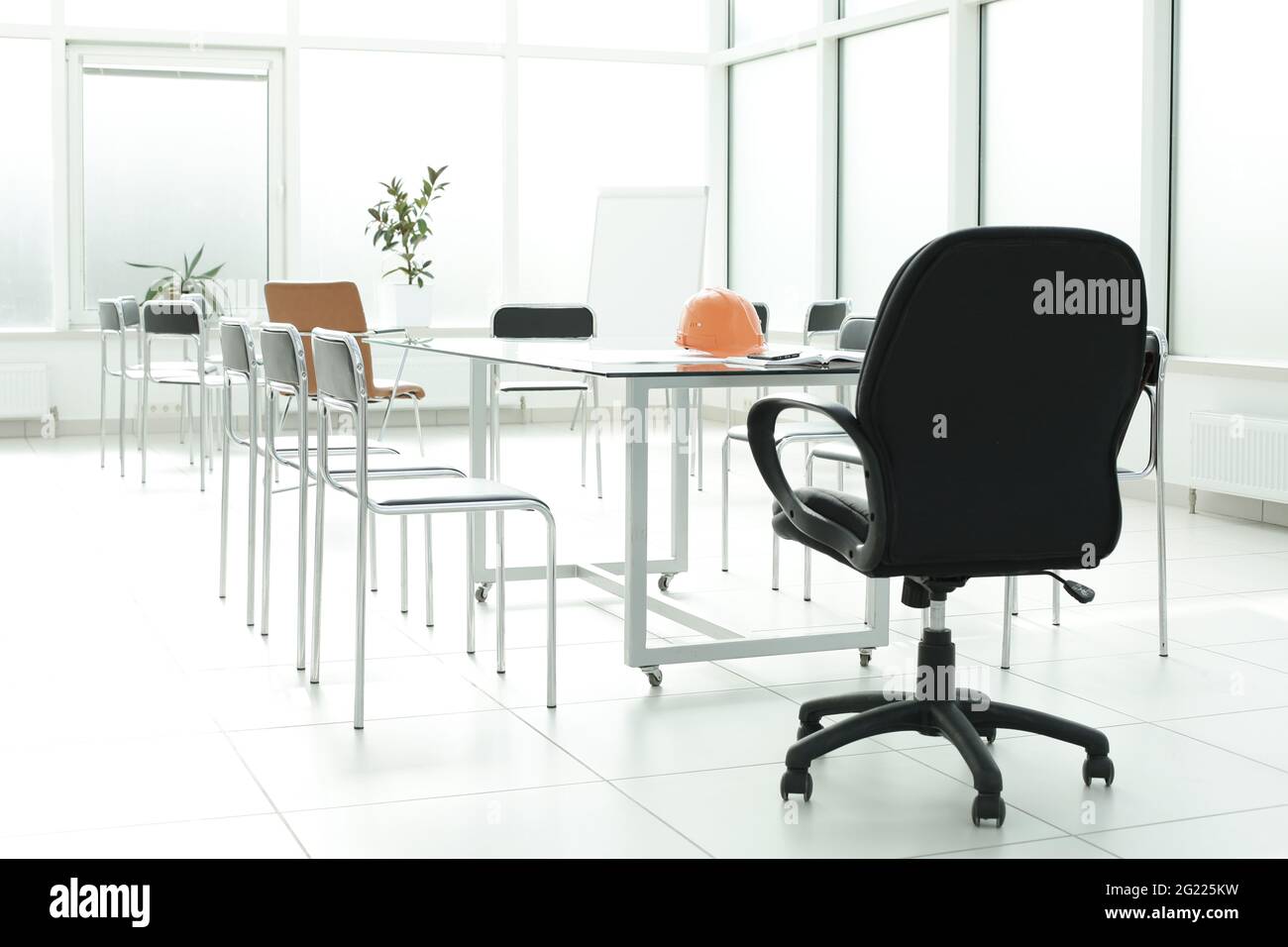 Flipchart construction helmet chairs glass table in a bright office ...