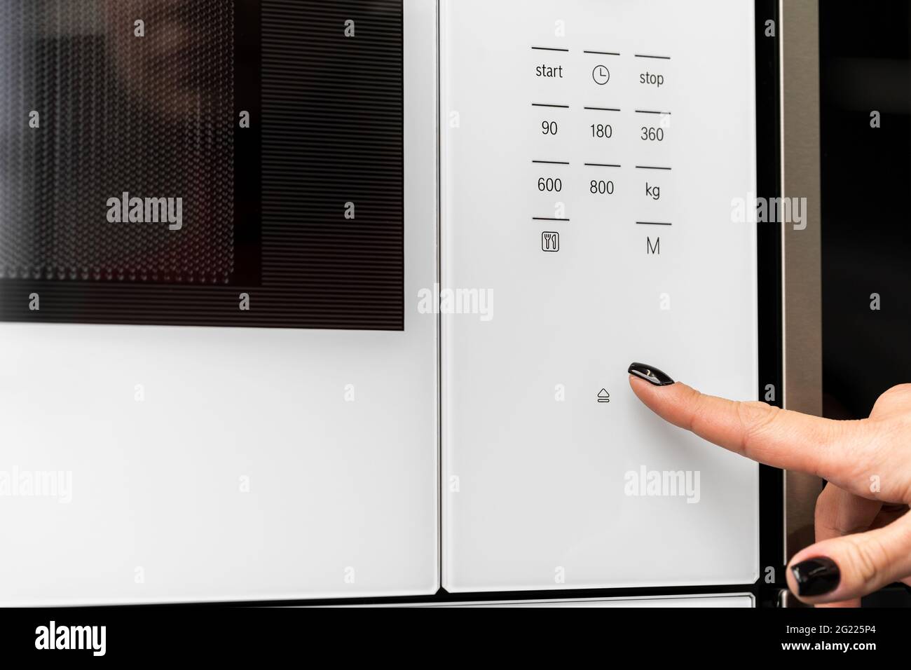 Female pushes button on microwave oven close up Stock Photo - Alamy