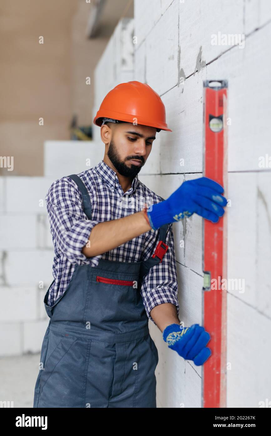 Mason checking plumb line of house wall being made from aerated ...