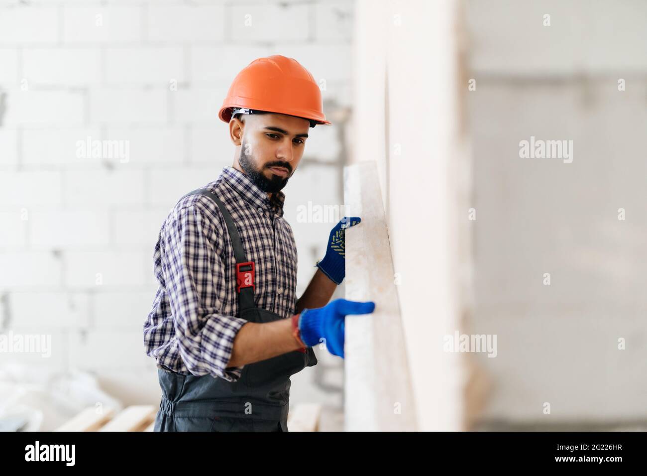Indian builder at facade plastering work during industrial building ...