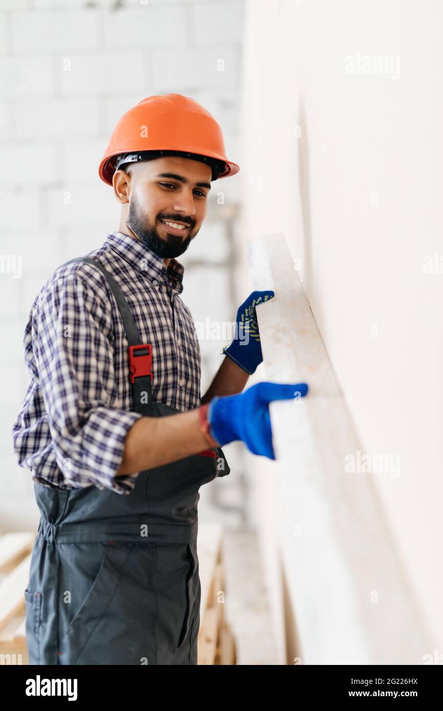 Indian builder at facade plastering work during industrial building ...