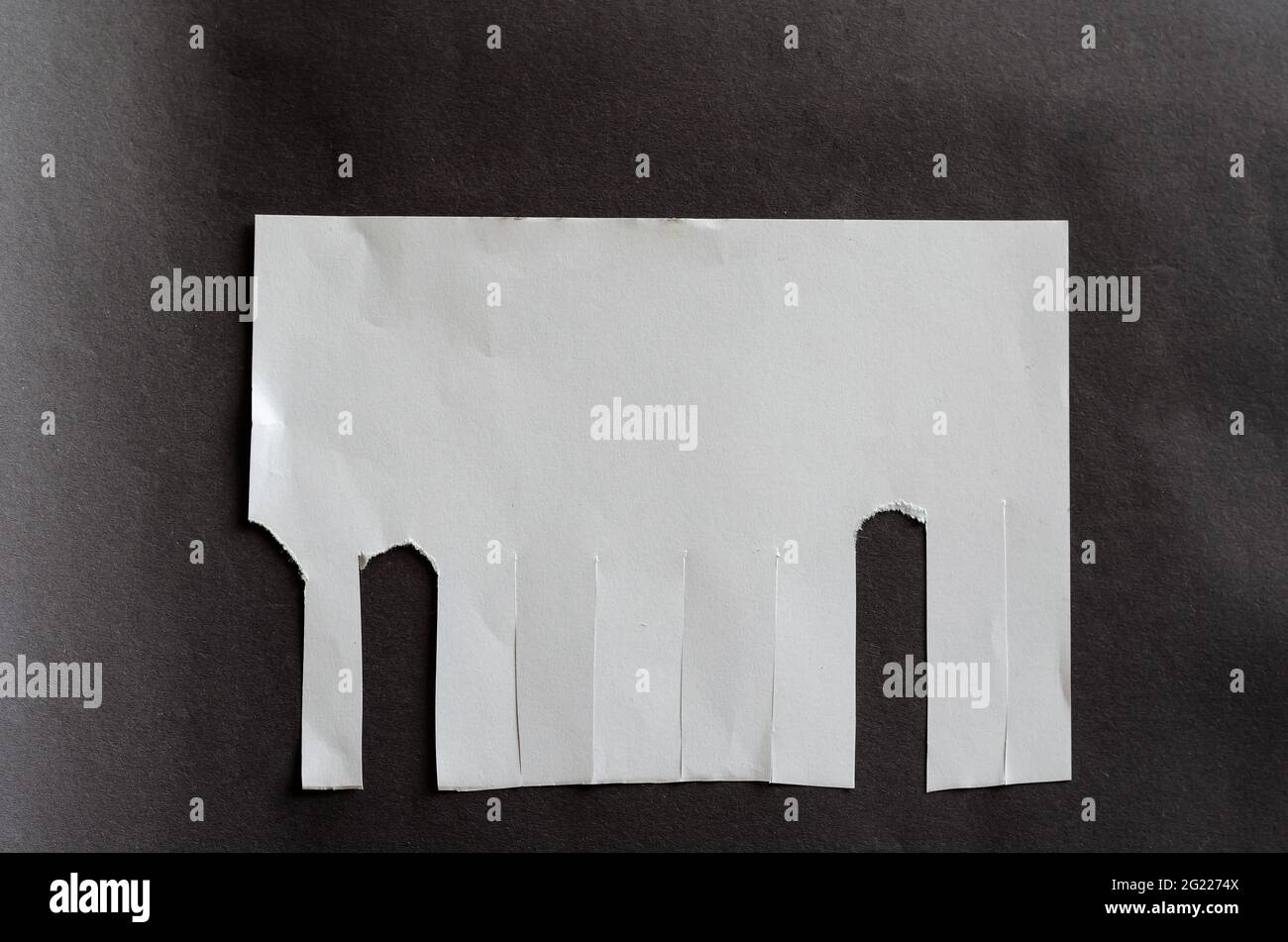 White blank sheet of paper with tear-off tabs on gray background ...