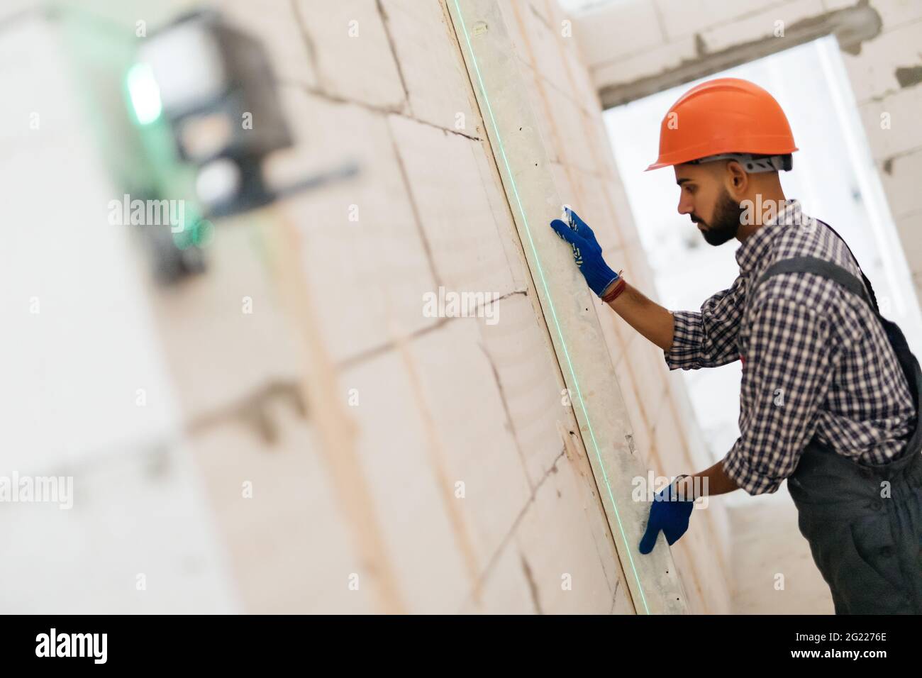 Young mason man worker with laser on the building site Stock Photo - Alamy
