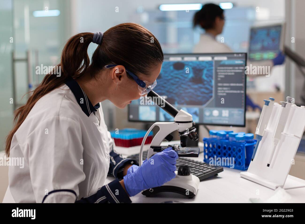 Doctor searching through microscope hi-res stock photography and images ...