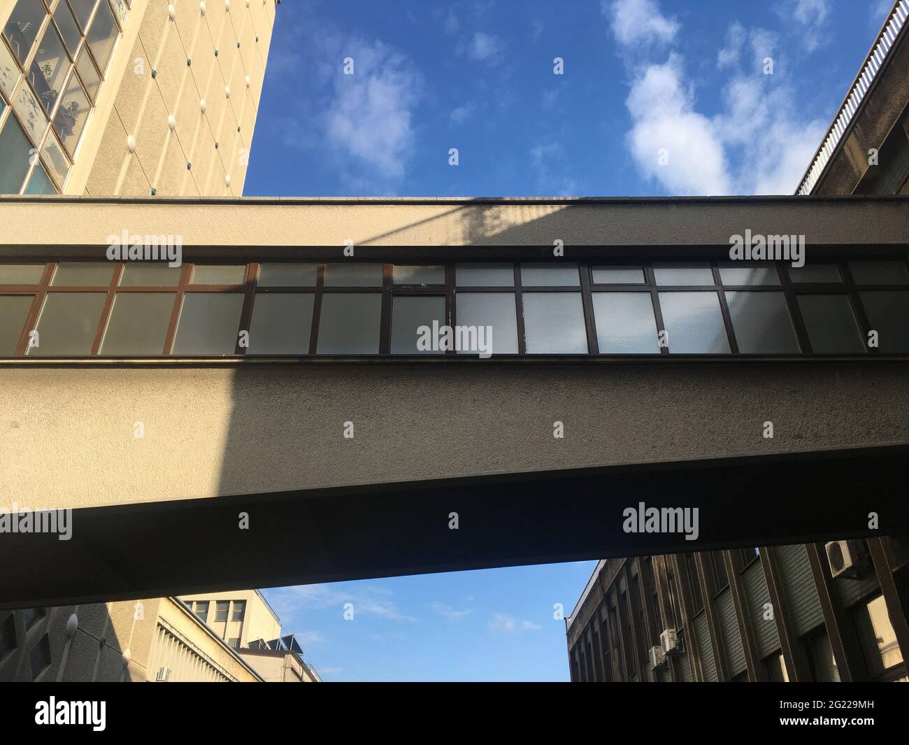 a bridge with wall, windows and roof connecting two buildings and a ...