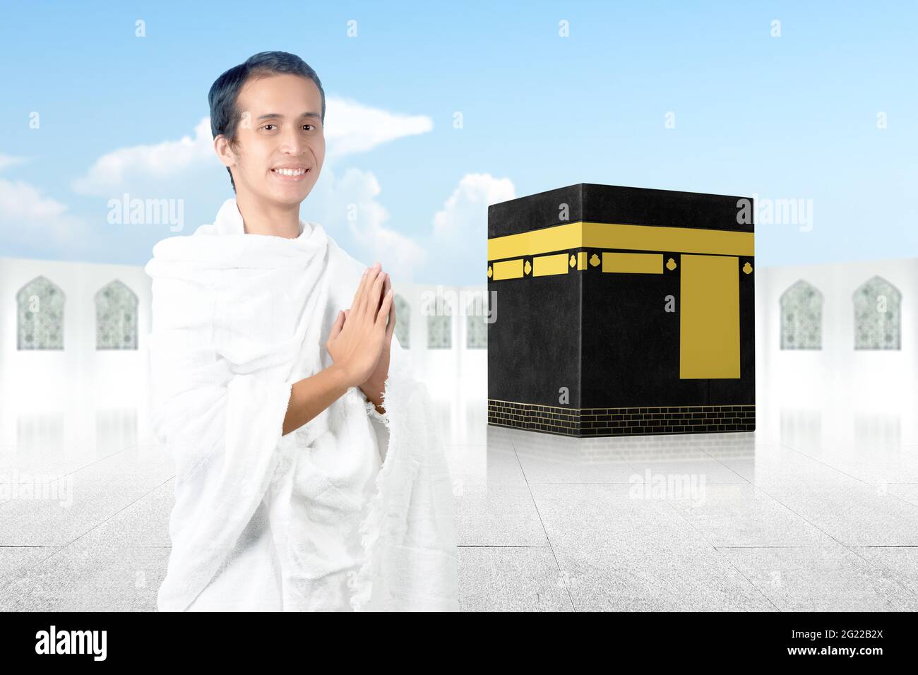 Asian Muslim man in ihram clothes standing with greetings gesture with ...