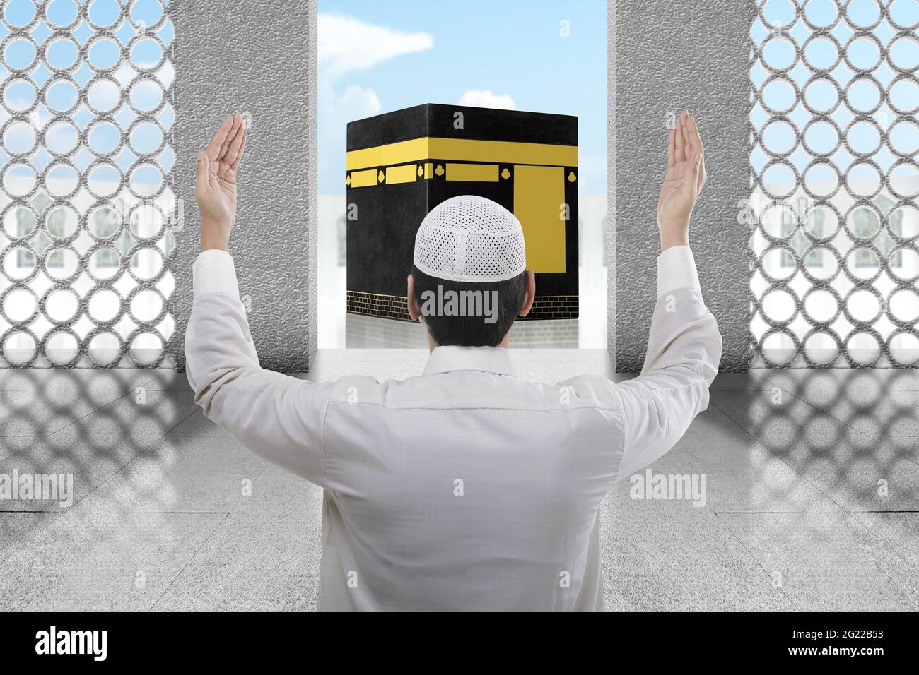 Rear view of Asian Muslim man standing and praying with Kaaba view and ...