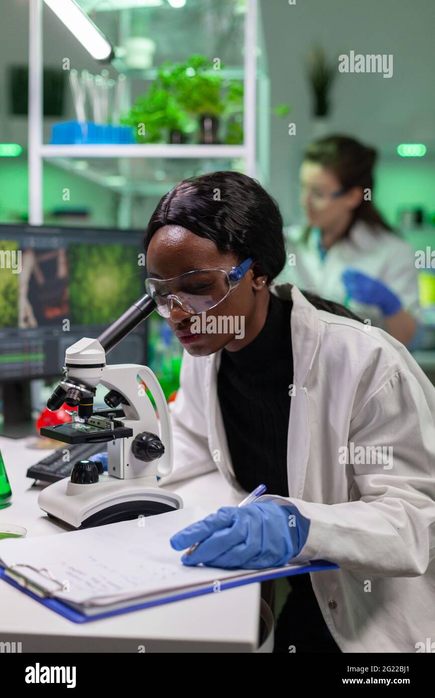 Biochemistry doctor examining chemical test using microscope for ...