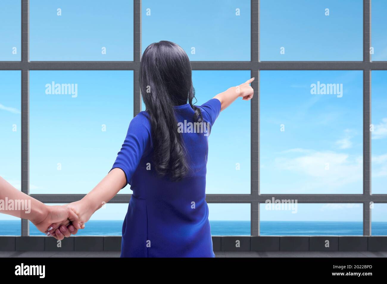 Rear view of Asian woman holding her boyfriend hands on the hotel and ...