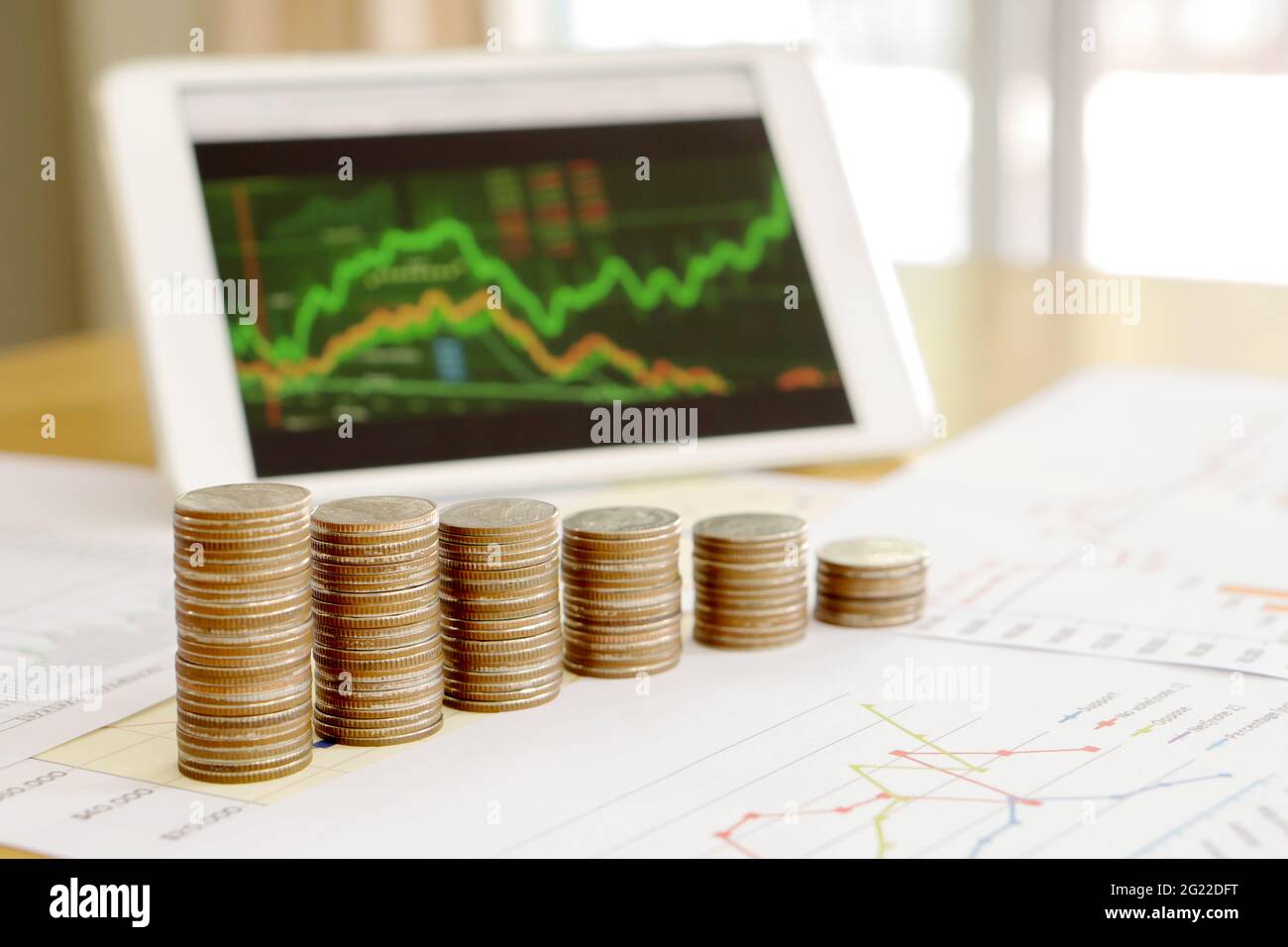 Grow up coins stack with business and finance graph screen on laptop ...