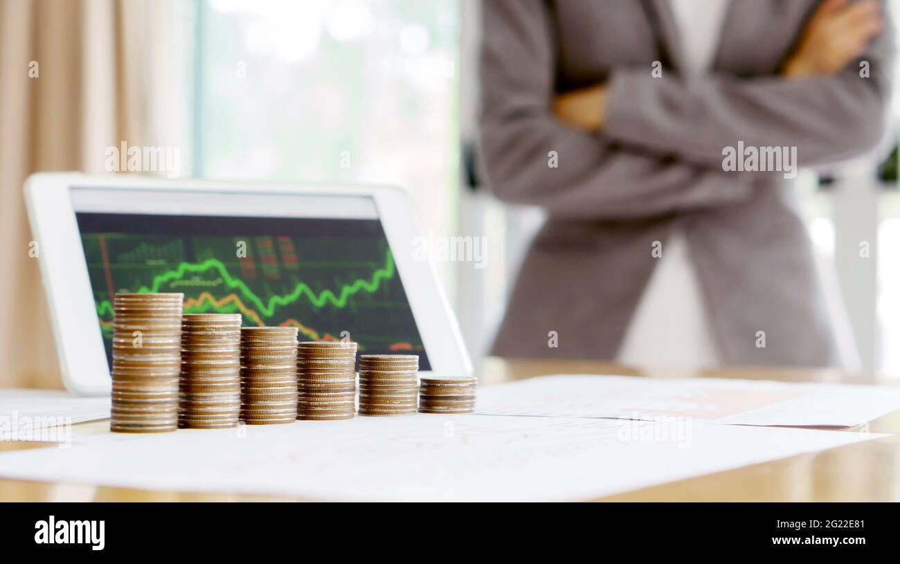 Grow up coins stack with business and finance graph screen on laptop ...