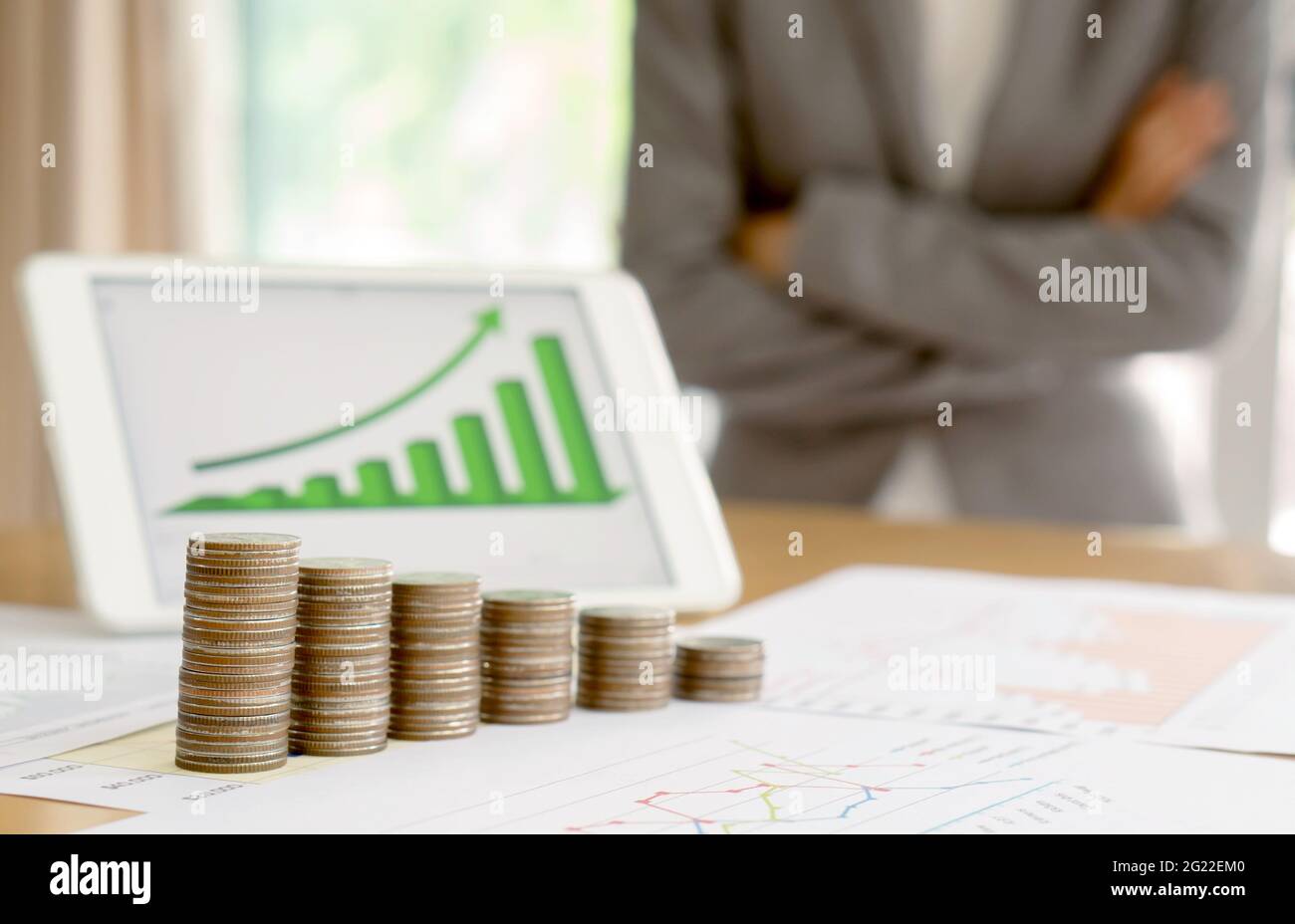 Grow up coins stack with business and finance graph screen on laptop ...