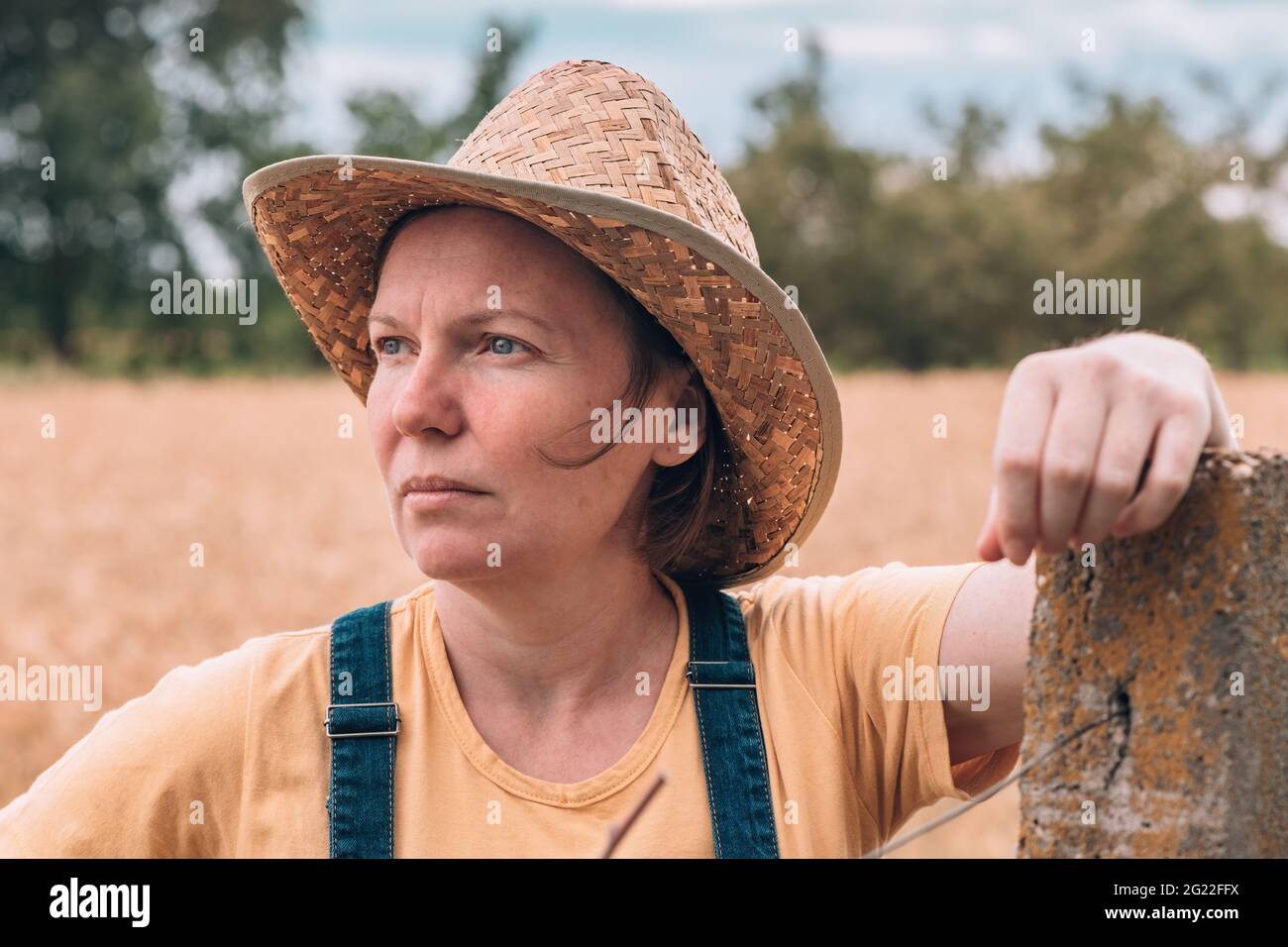 Female farmer posing in ripe barley field just before the harvest ...