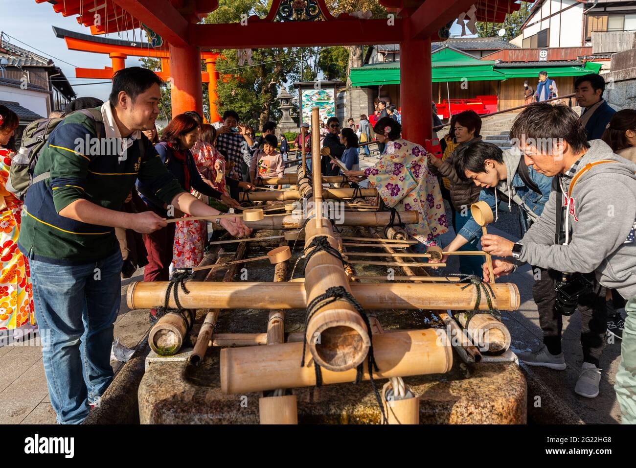 Kyoto, Japan - November 21, 2018: Tourist scooping and pouring holy ...