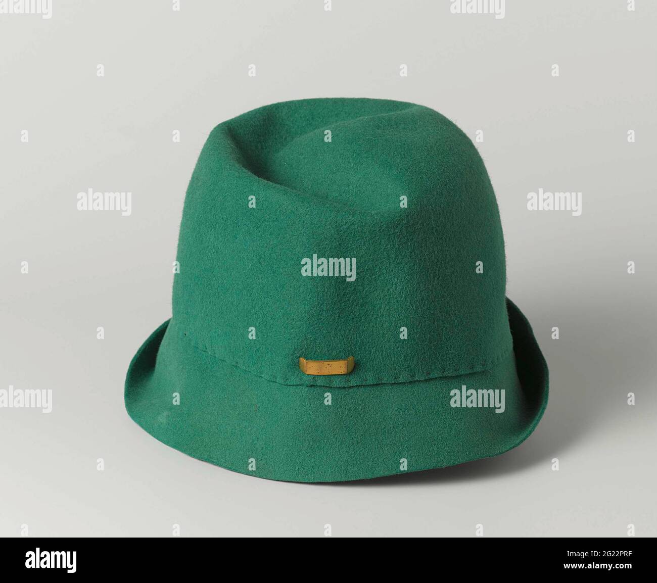 Cloche of green felt with small clip of yellow copper. Cloche of green ...