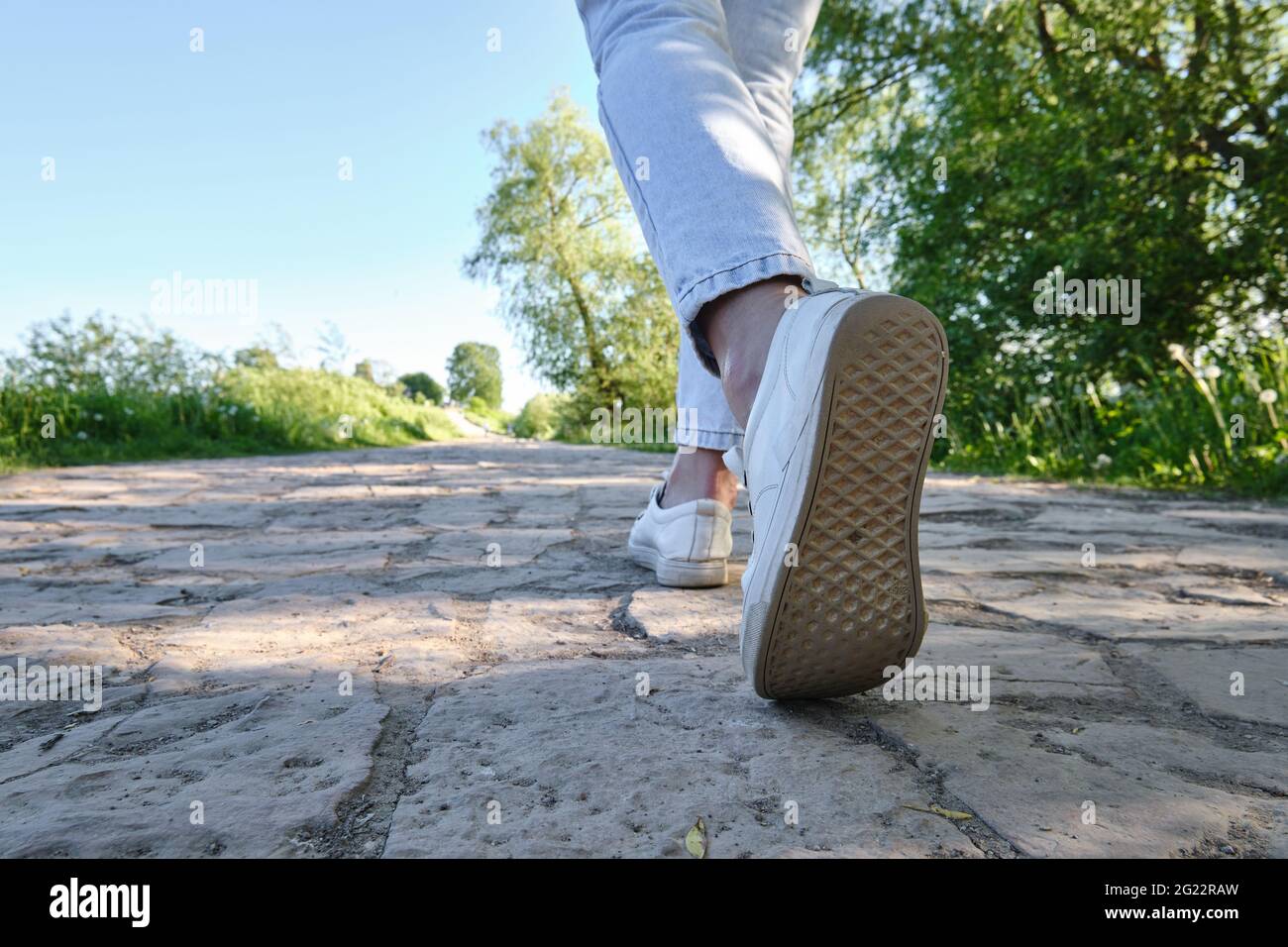 A man walks along the road. Close-up of a foot. Bottom view, back view ...