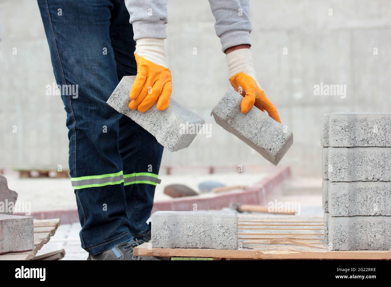 Paving stone worker is putting down pavers during a construction of a ...