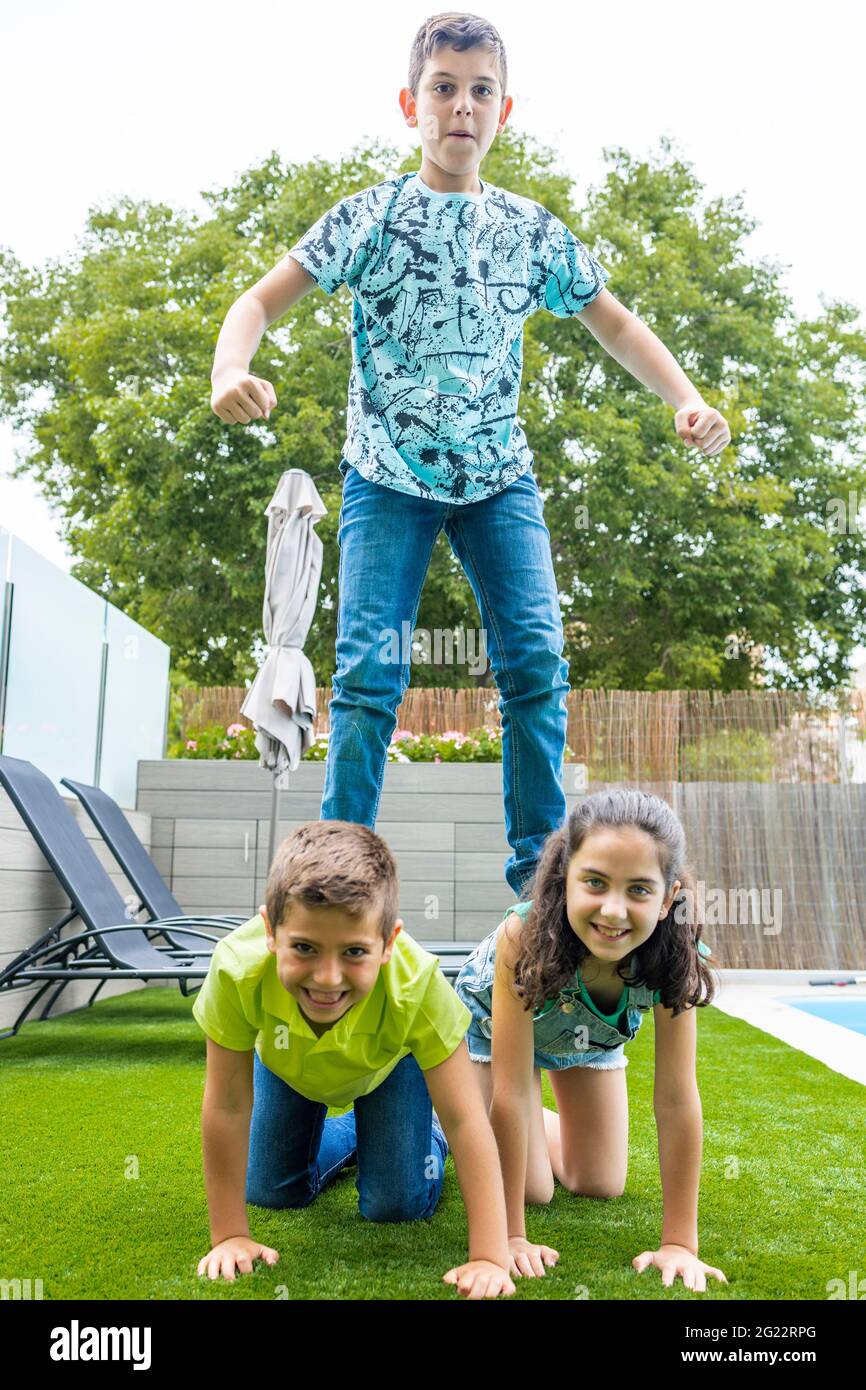 Three friends making an human tower Stock Photo - Alamy