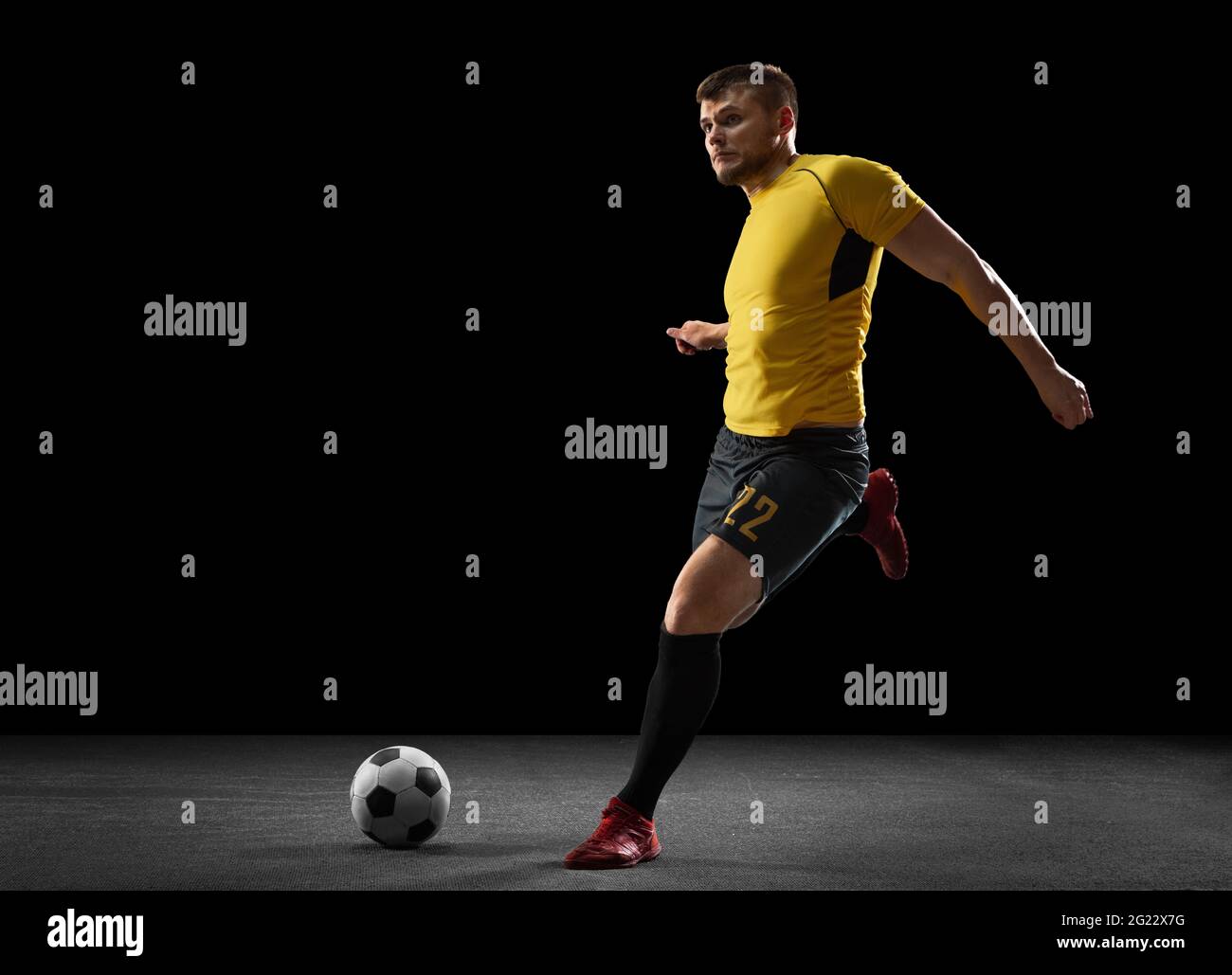 Powerful, flying above the field. Young football, soccer player in ...