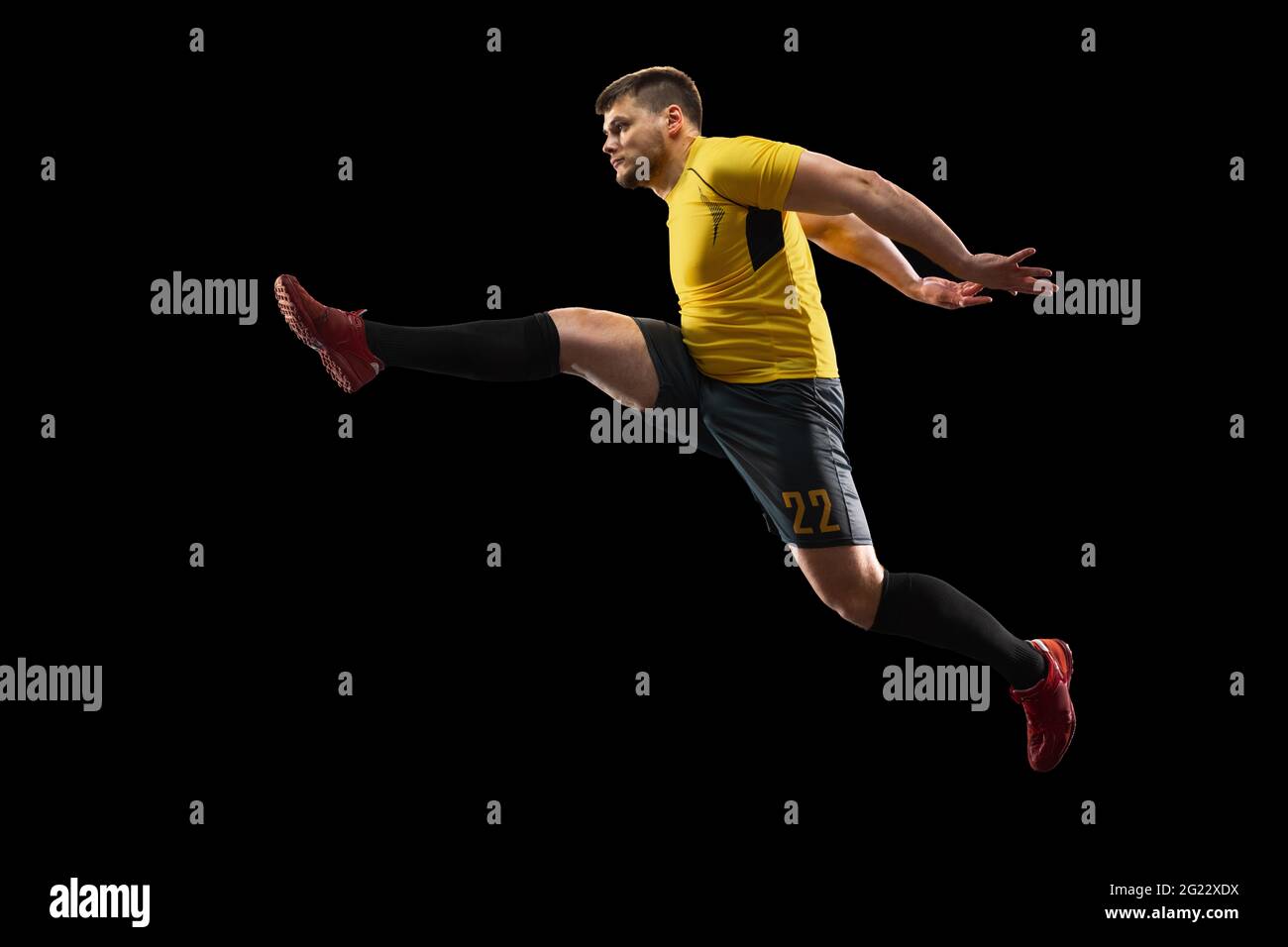 Powerful, flying above the field. Young football, soccer player in ...